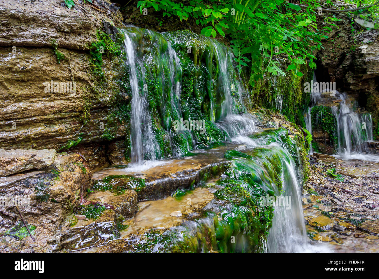 Holy springs in Izborsk. A small waterfall in Russia. Descent of water ...