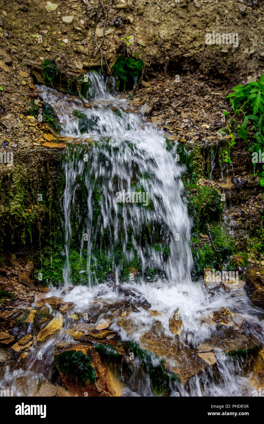 Holy springs in Izborsk. A small waterfall in Russia. Descent of water ...