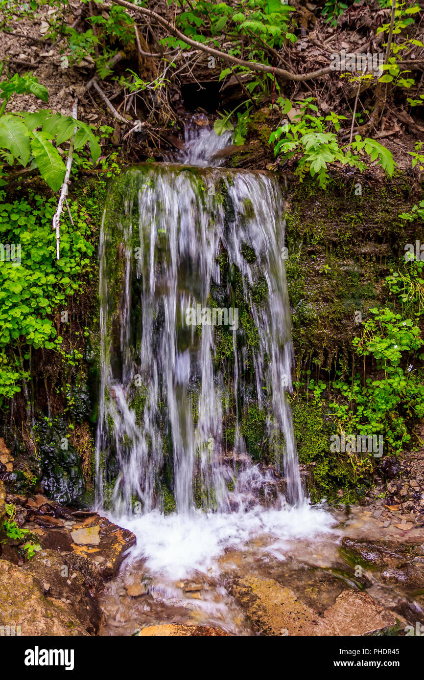Holy springs in Izborsk. A small waterfall in Russia. Descent of water ...