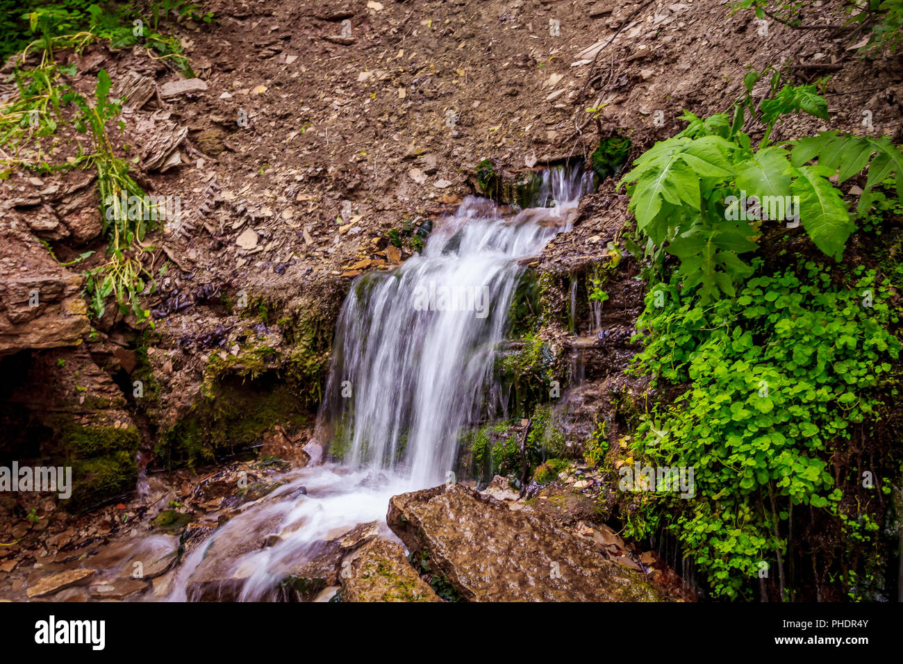 Holy springs in Izborsk. A small waterfall in Russia. Descent of water ...