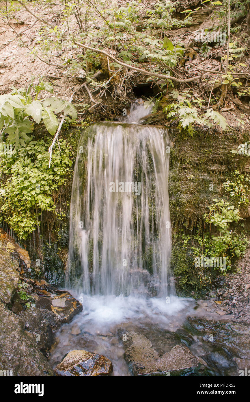Holy springs in Izborsk. A small waterfall in Russia. Descent of water ...