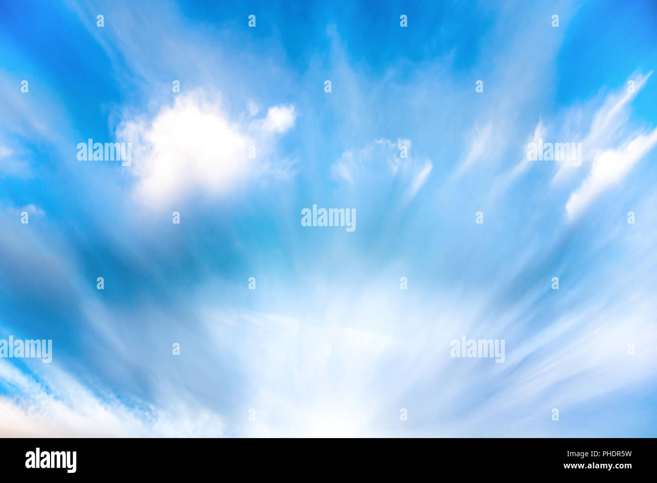 Sun rays shining through blue clouds Stock Photo - Alamy