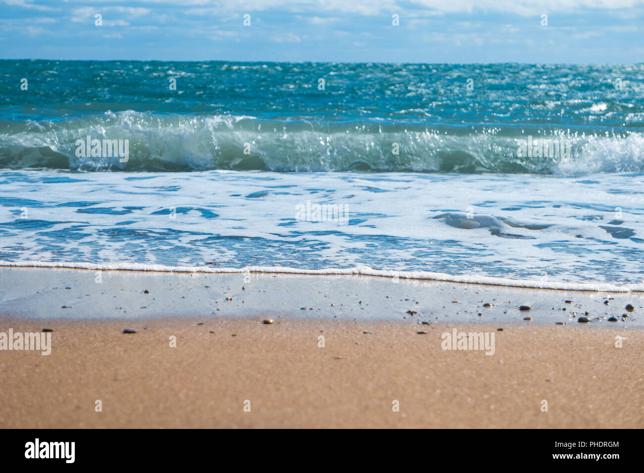 Blue sea and beach with golden sand Stock Photo - Alamy