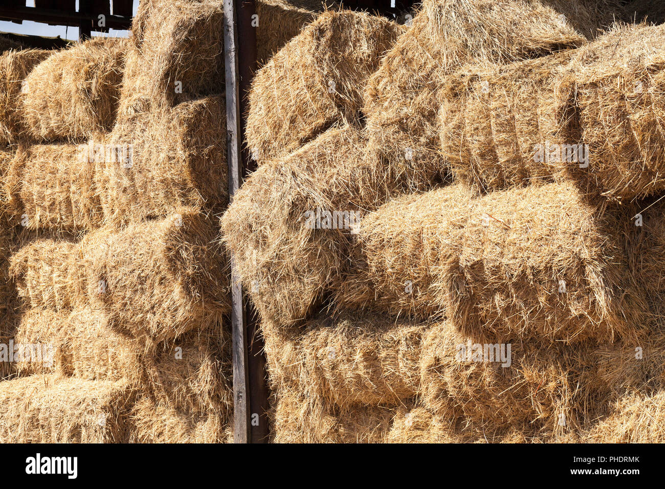 square stacks of straw stacked in a tall pile in the hayloft for ...
