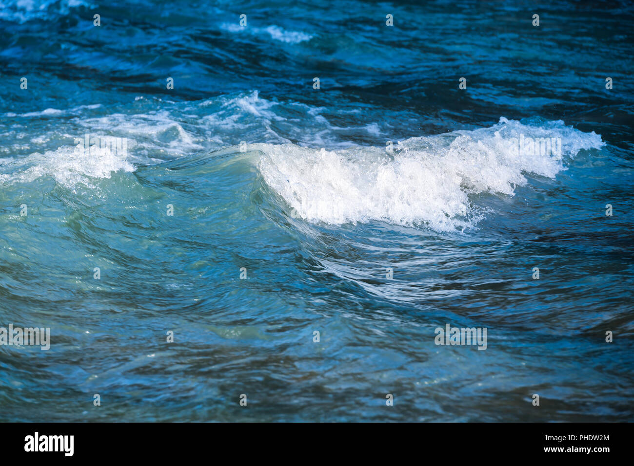Sea wave on dark blue water Stock Photo - Alamy
