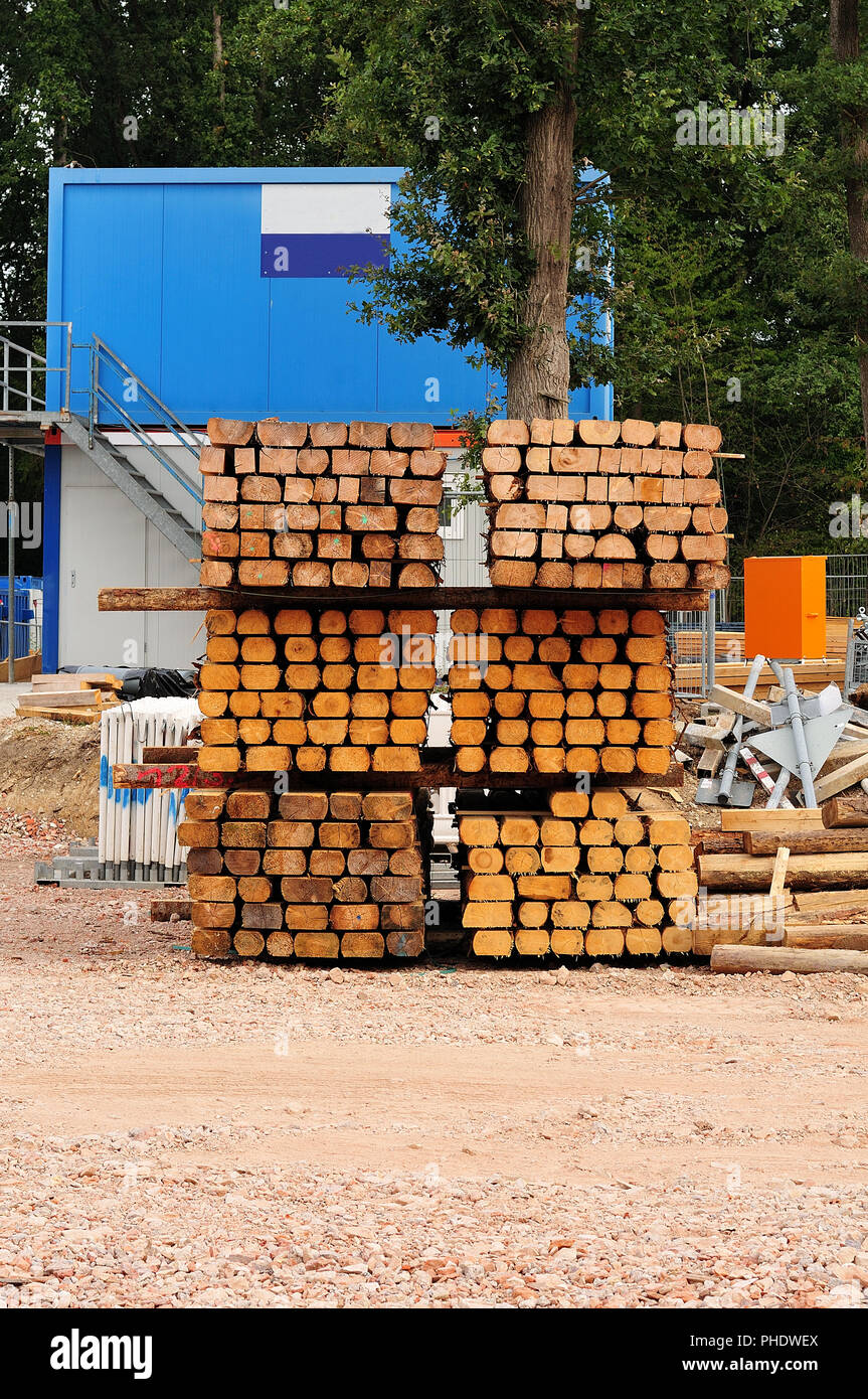 construction site with blue container and stack of lumber wood stored ...