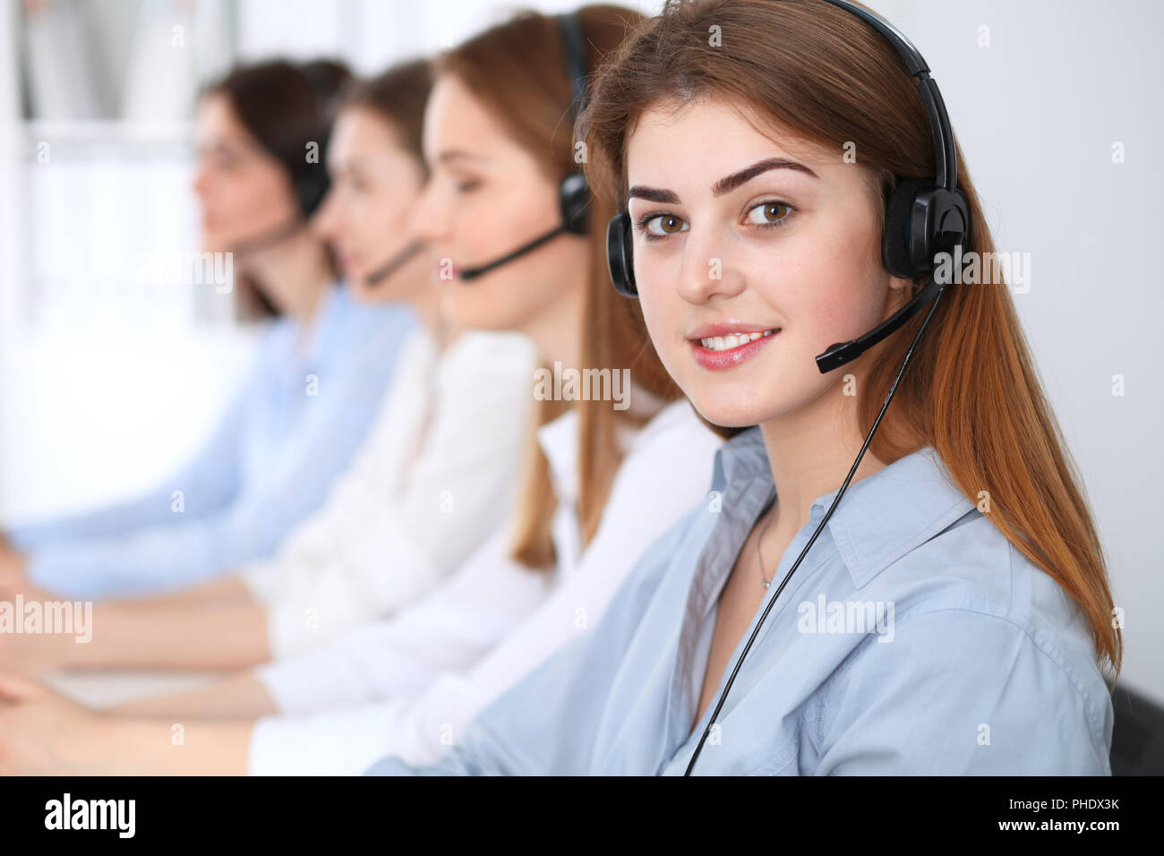 Call center. Beautiful cheerful smiling operator consulting clients ...