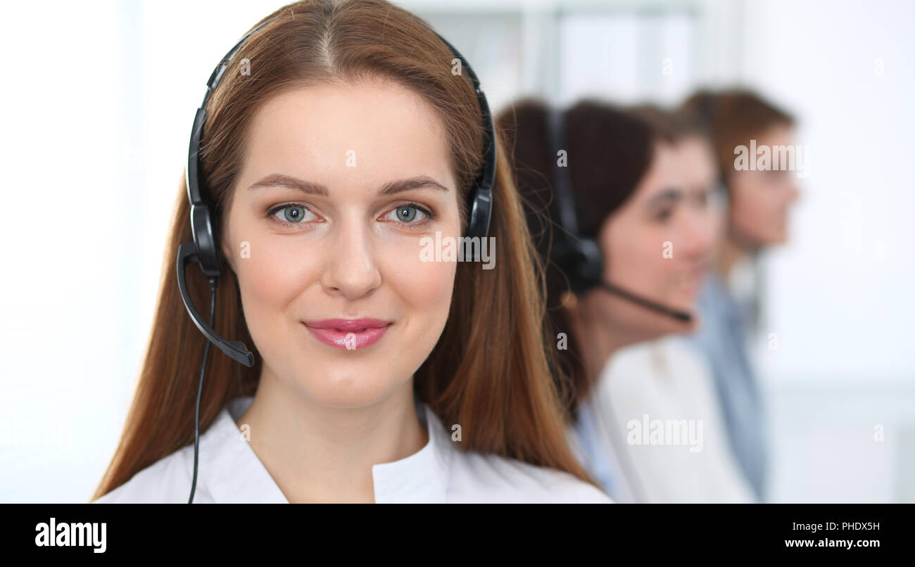 Call center. Beautiful cheerful smiling operator consulting clients ...