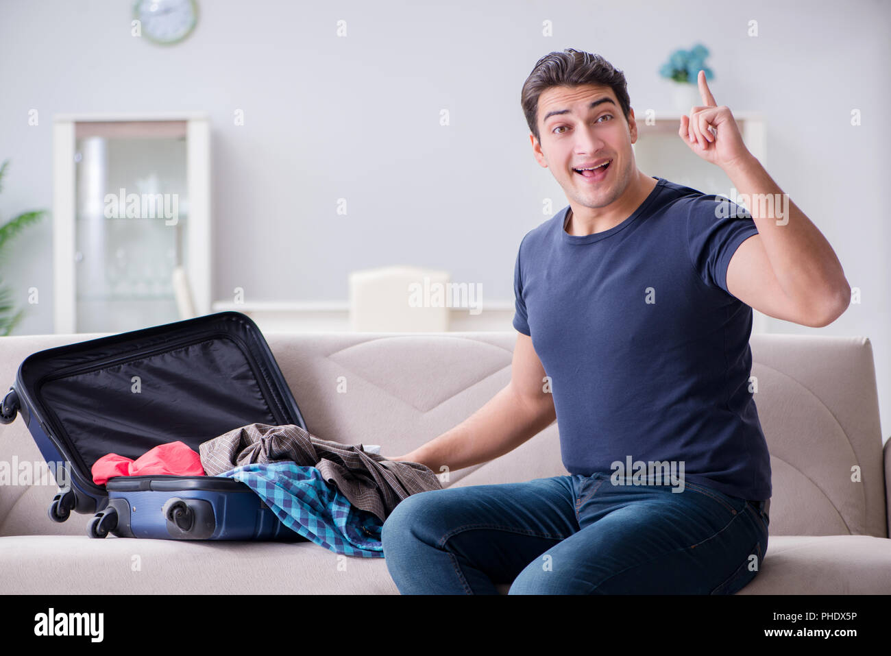 Young man preparing packing for summer vacation Stock Photo - Alamy
