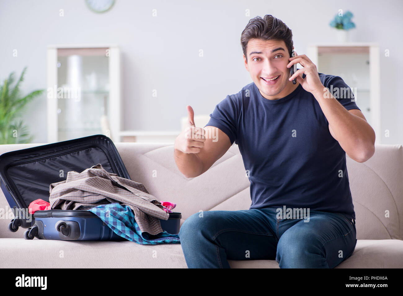 Young man preparing packing for summer vacation Stock Photo - Alamy
