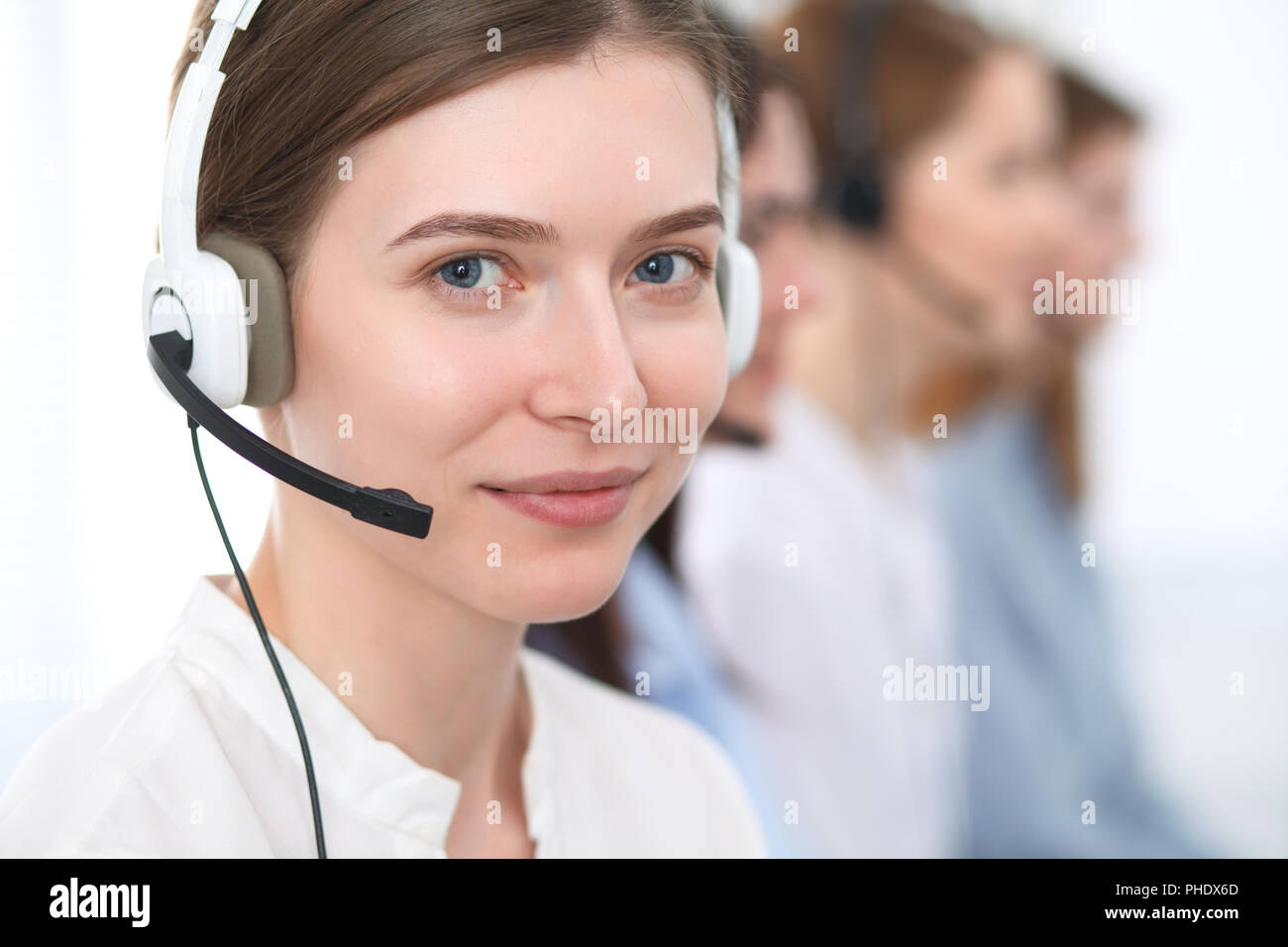 Call center. Beautiful cheerful smiling operator consulting clients ...