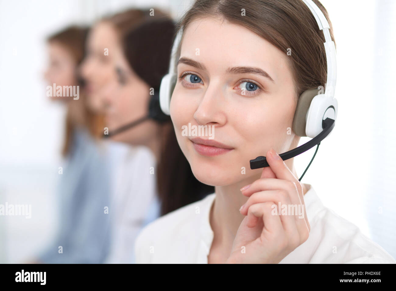 Call center. Beautiful cheerful smiling operator consulting clients ...