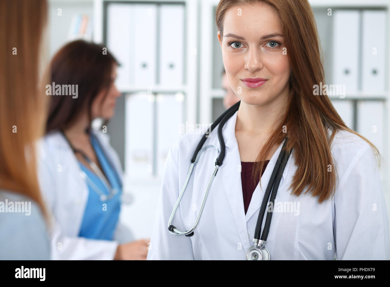 Young beautiful female doctor smiling while consulting her patient ... Young beautiful female doctor smiling while consulting her patient ...