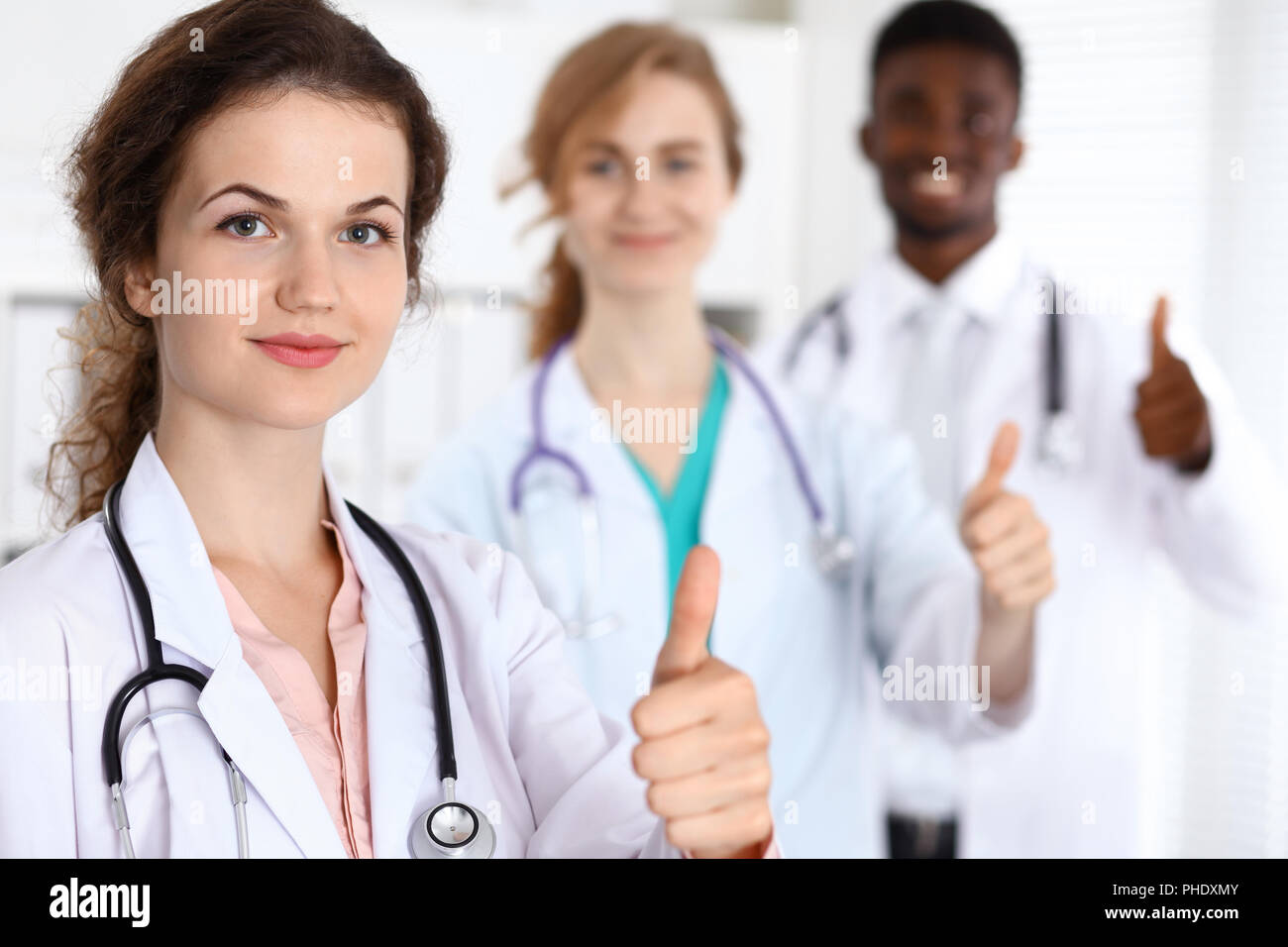 Medical team of confident doctors showing Ok sign with thumbs up ...