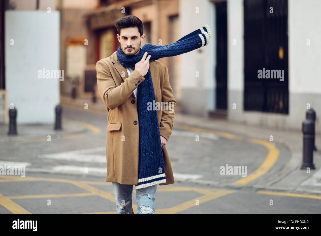 Young man wearing winter clothes in the street. Young bearded guy with ...