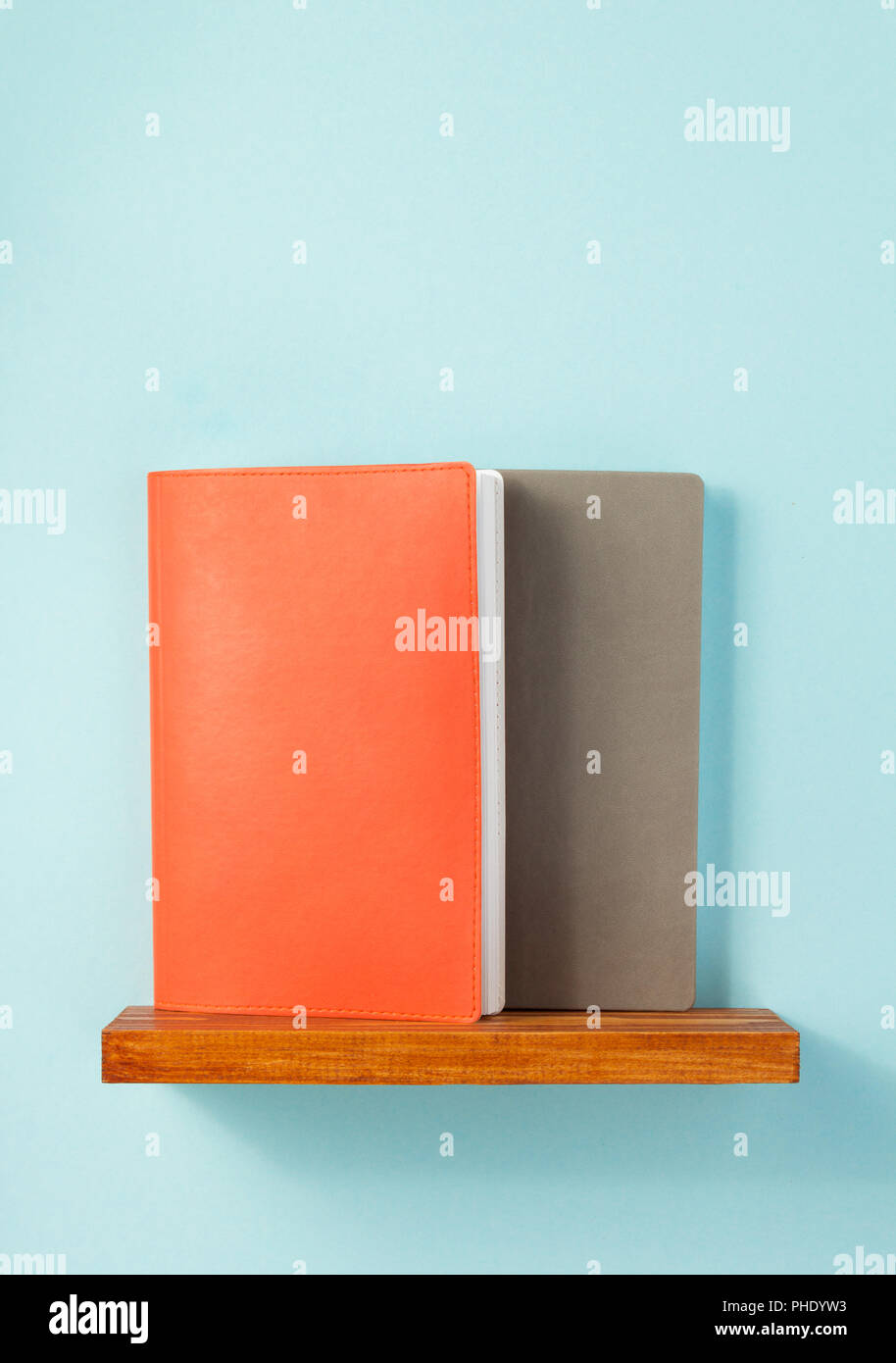 notepad and book on shelf at wall background surface Stock Photo - Alamy