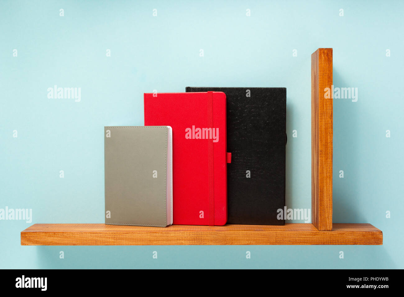 notepad and book on shelf at wall background surface Stock Photo - Alamy