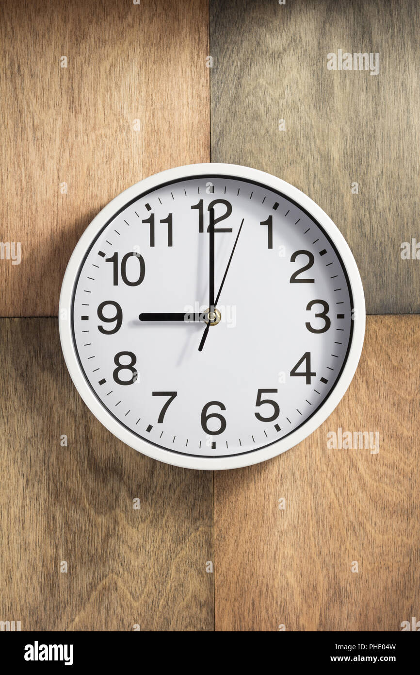 wall clock at wooden background surface Stock Photo - Alamy