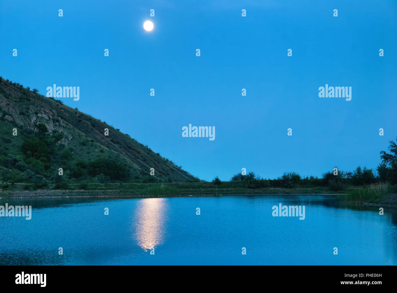 Landscape with moon above the lake Stock Photo - Alamy