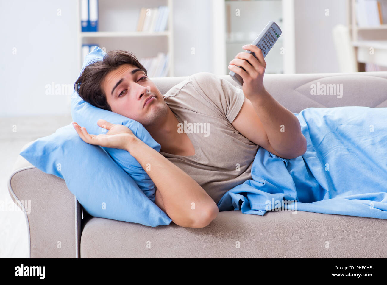 Man watching tv from bed holding remote control unit Stock Photo - Alamy