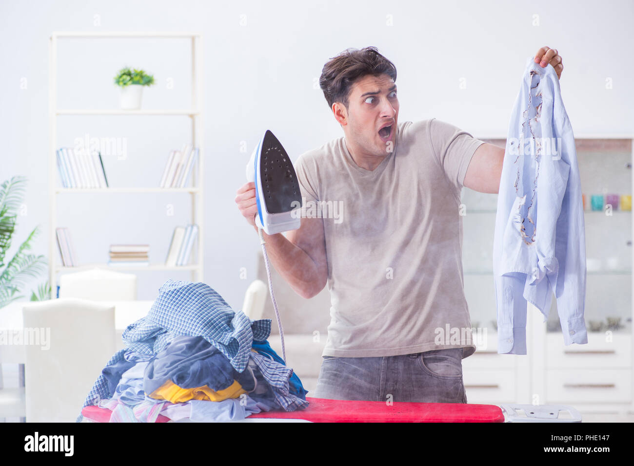 Inattentive husband burning clothing while ironing Stock Photo - Alamy