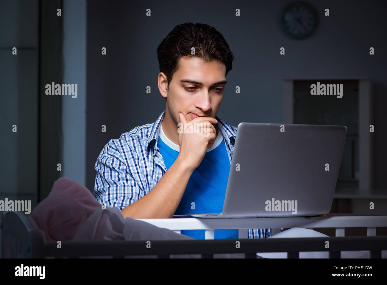 Young student doing homework and looking after newborn baby Stock Photo ...