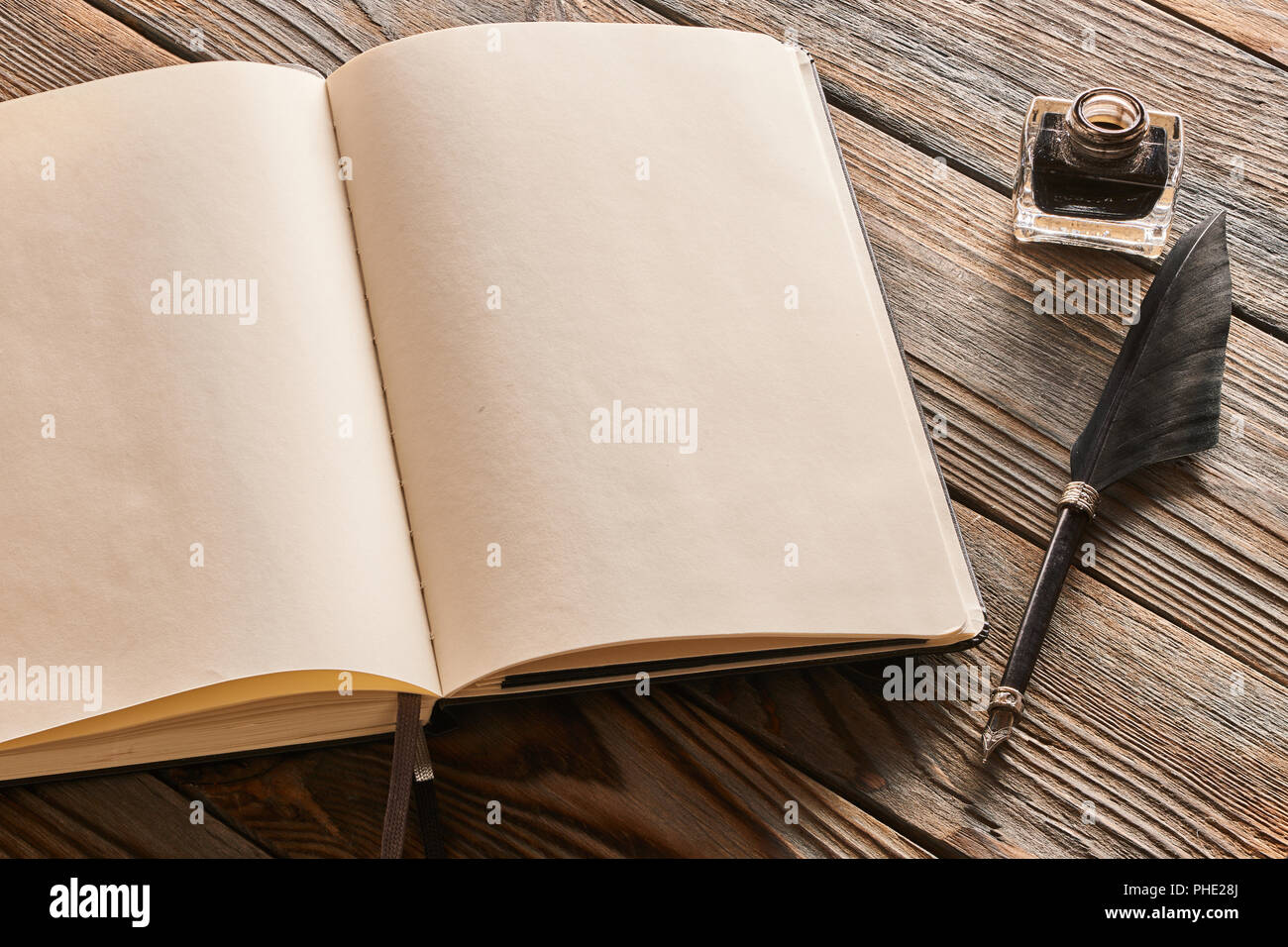 Feather pen and blank notebook page Stock Photo - Alamy