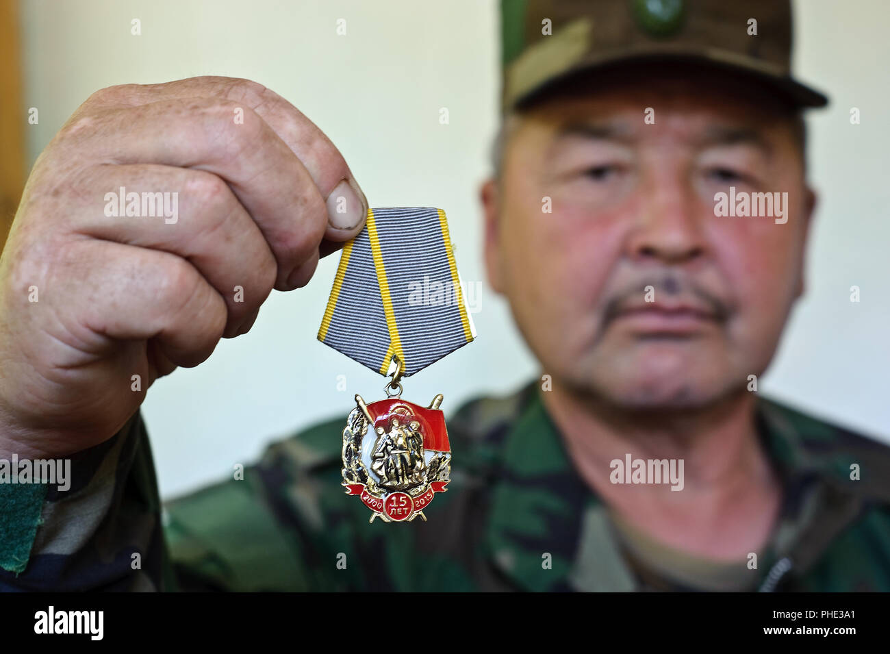 Retired army man showing a medal he got for fighting against ...