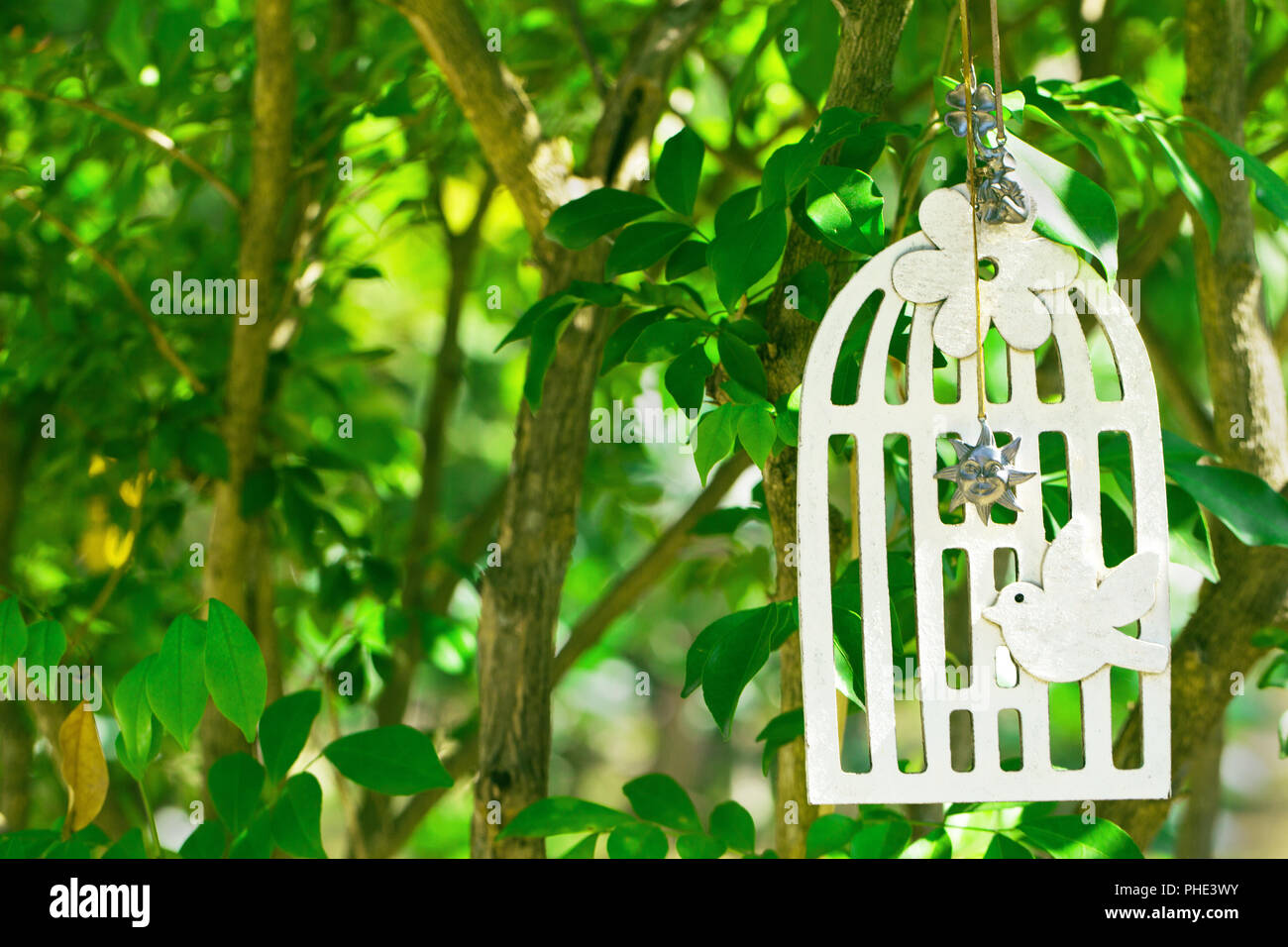Decorative cage with a bird on a tree branch in the garden Stock Photo ...