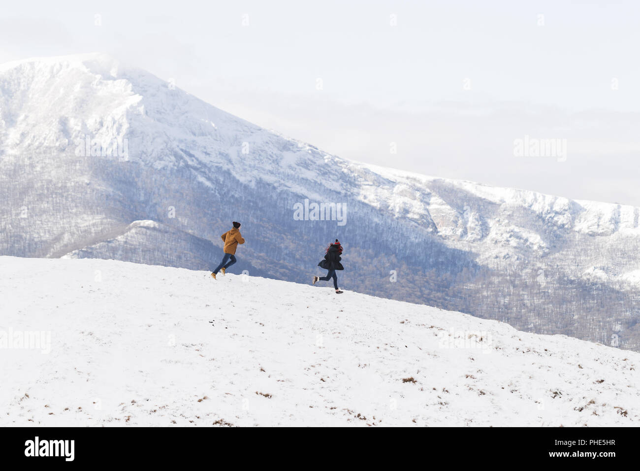People having fun and running in mountains on the background of high ...