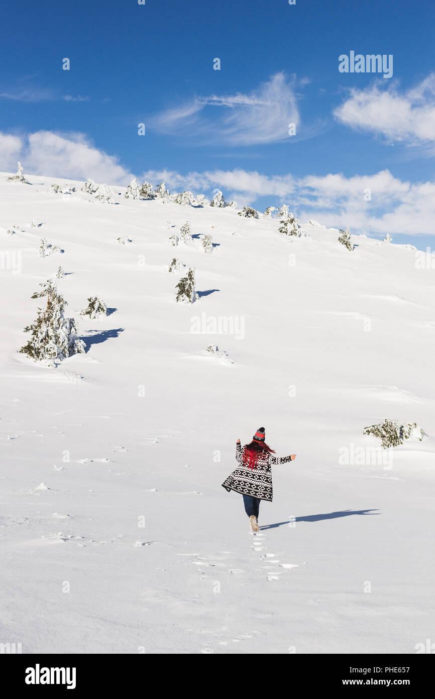 Woman in knitted cardigan running at virgin snow field high in mountains. Happy emotions Stock ...