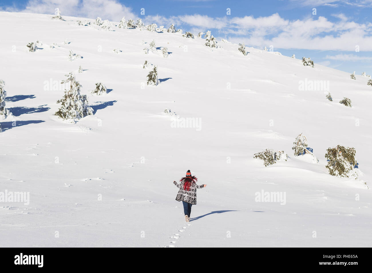 Woman in knitted cardigan running at virgin snow field high in mountains. Happy emotions Stock ...