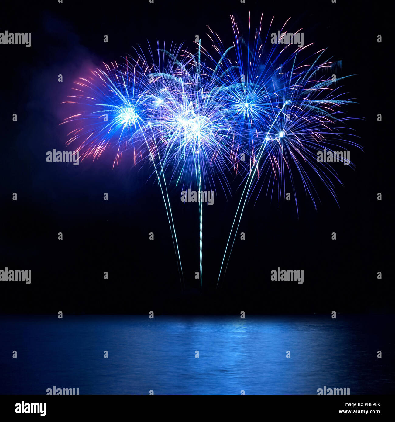 Blue fireworks above water Stock Photo - Alamy