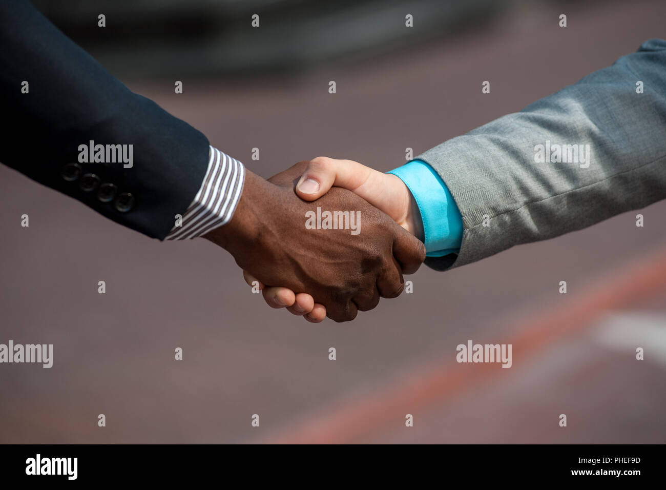 Two men in suits greeting each other at street bokeh background Stock ...