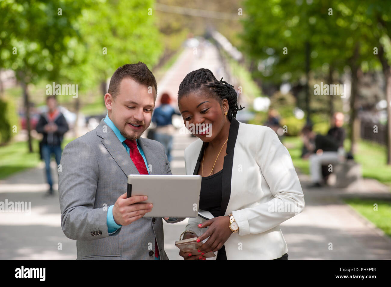 Two people multi race at street sunny background with computer device ...