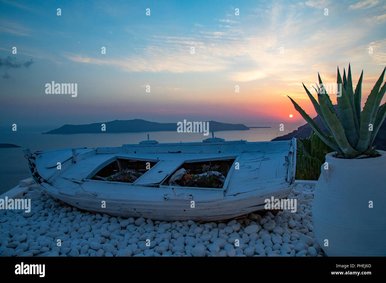 Scenic overlook of old row boat at sunset in Thira, Fira, Santorini ...