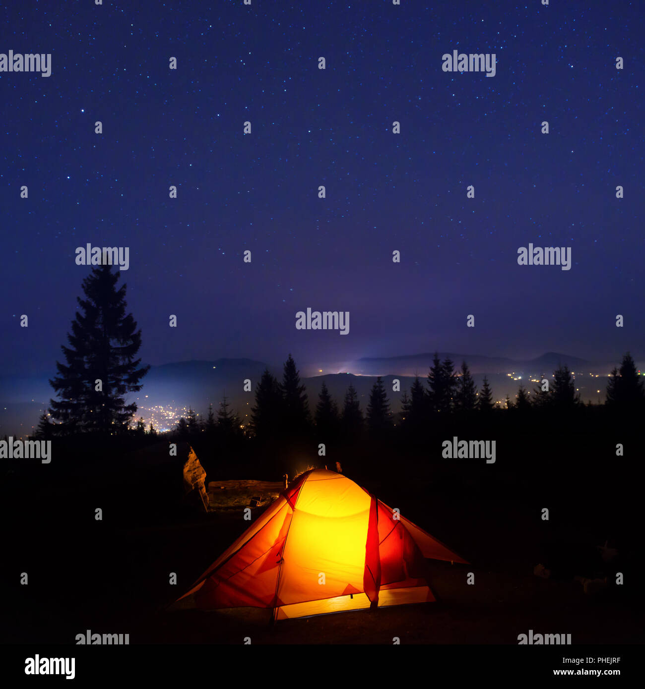 Illuminated orange camping tent Stock Photo - Alamy