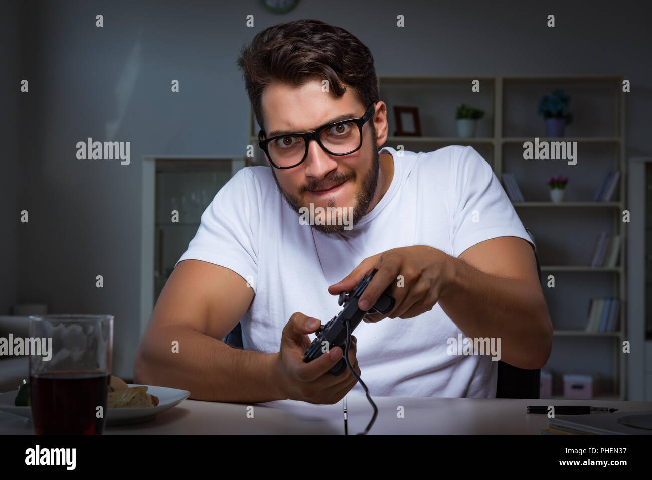 Young man playing games long hours late in the office Stock Photo - Alamy