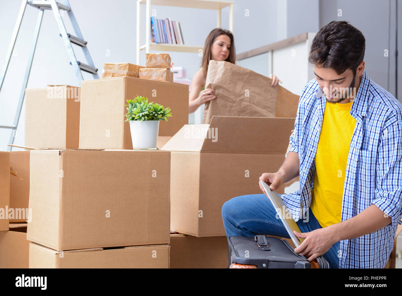 Young family unpacking at new house with boxes Stock Photo - Alamy