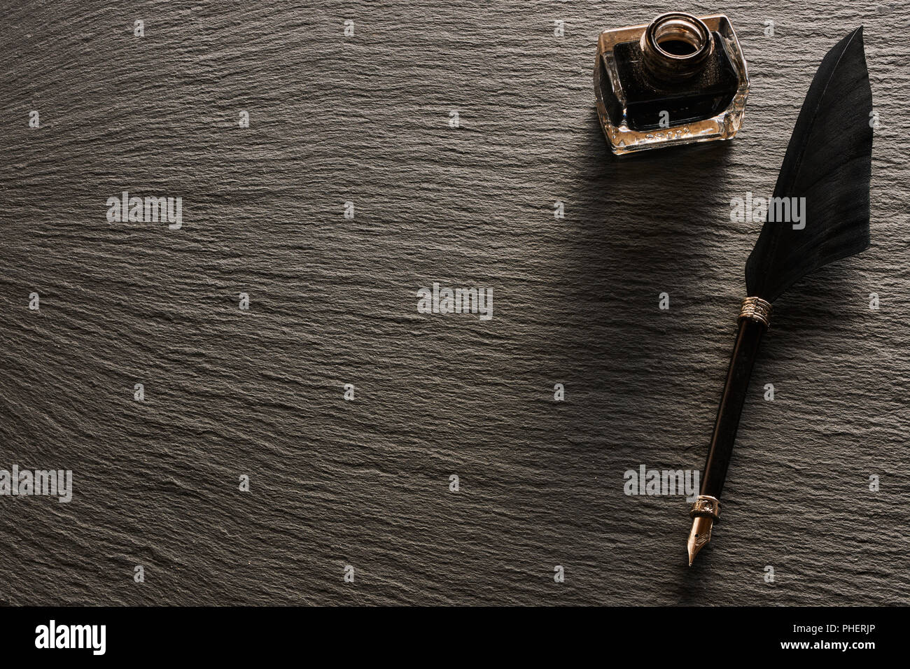 Feather pen and inkwell over slate Stock Photo - Alamy
