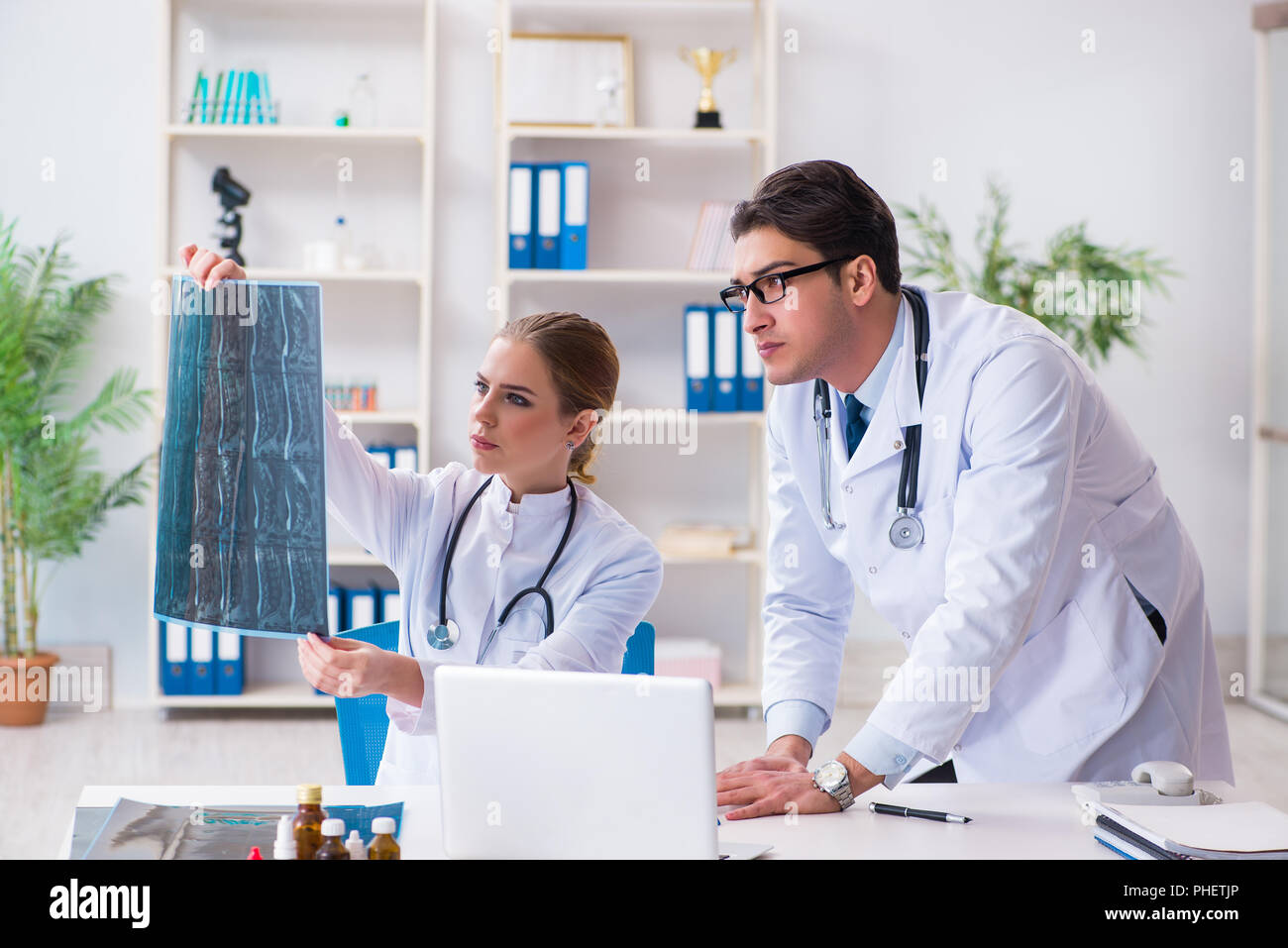 Two doctors examining x-ray images of patient for diagnosis Stock Photo ...