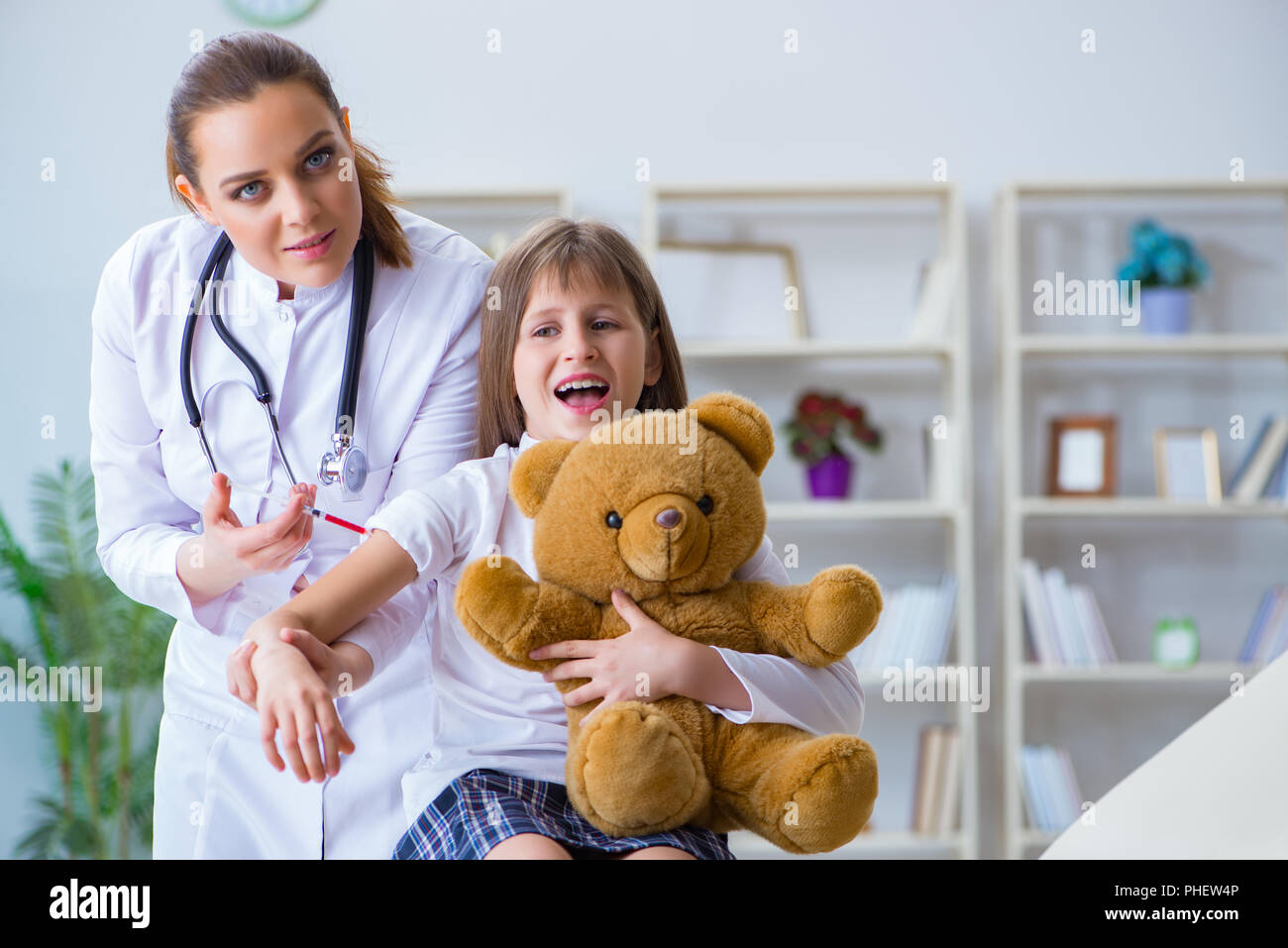 Woman female doctor examining little cute girl with toy bear Stock ...
