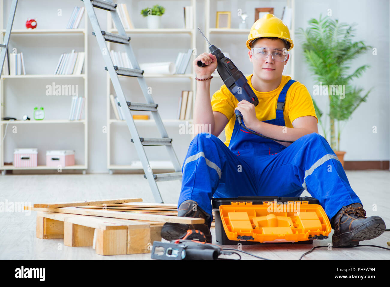 Young man assembling wood pallet Stock Photo - Alamy