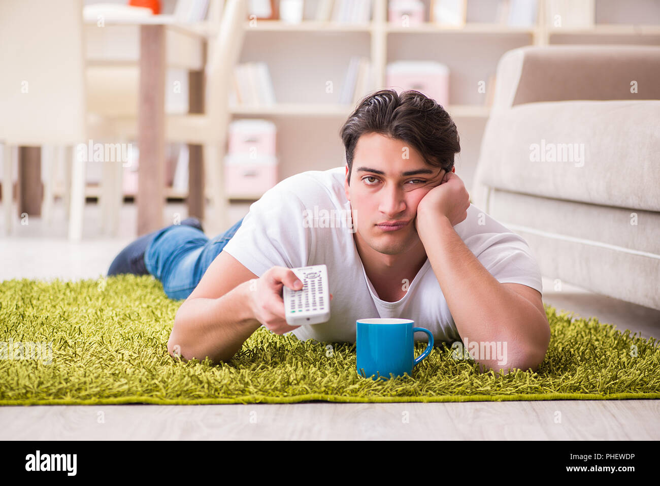 Man watching tv at home on floor Stock Photo - Alamy