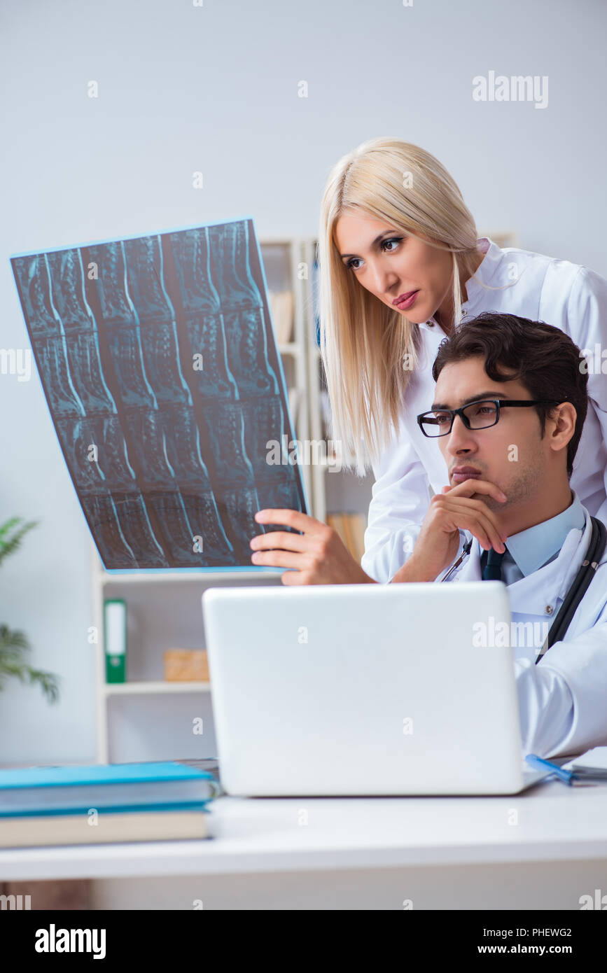 Two doctors examining x-ray images of patient for diagnosis Stock Photo ...