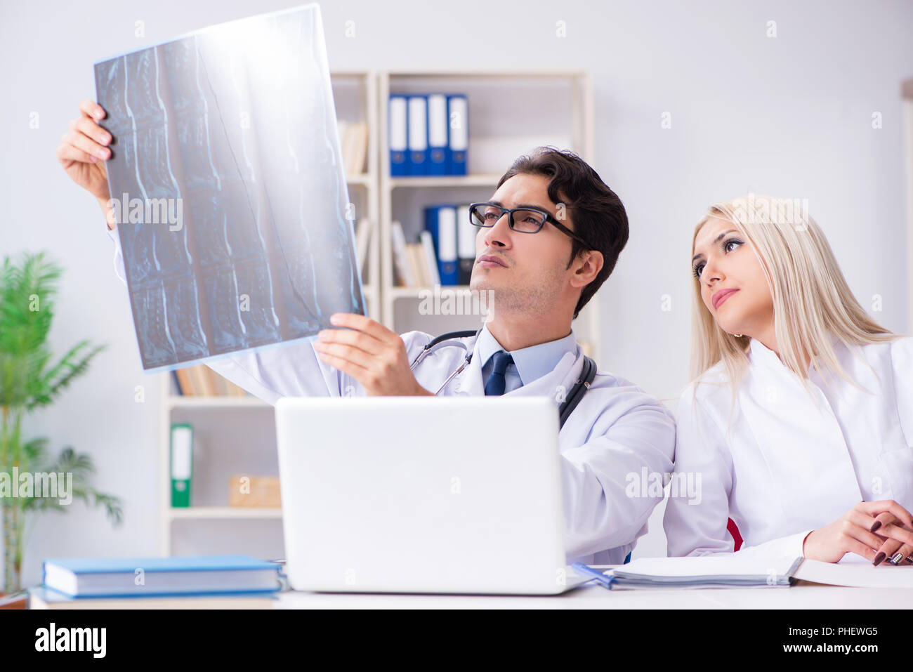 Two doctors examining x-ray images of patient for diagnosis Stock Photo ...