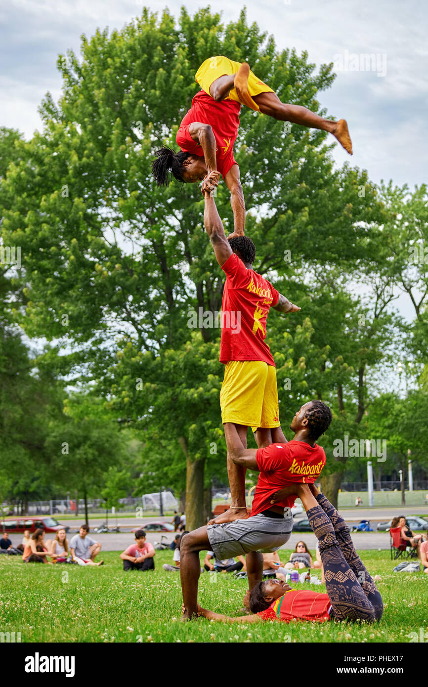 African male and female acrobats performing acrobatics show in front of ...