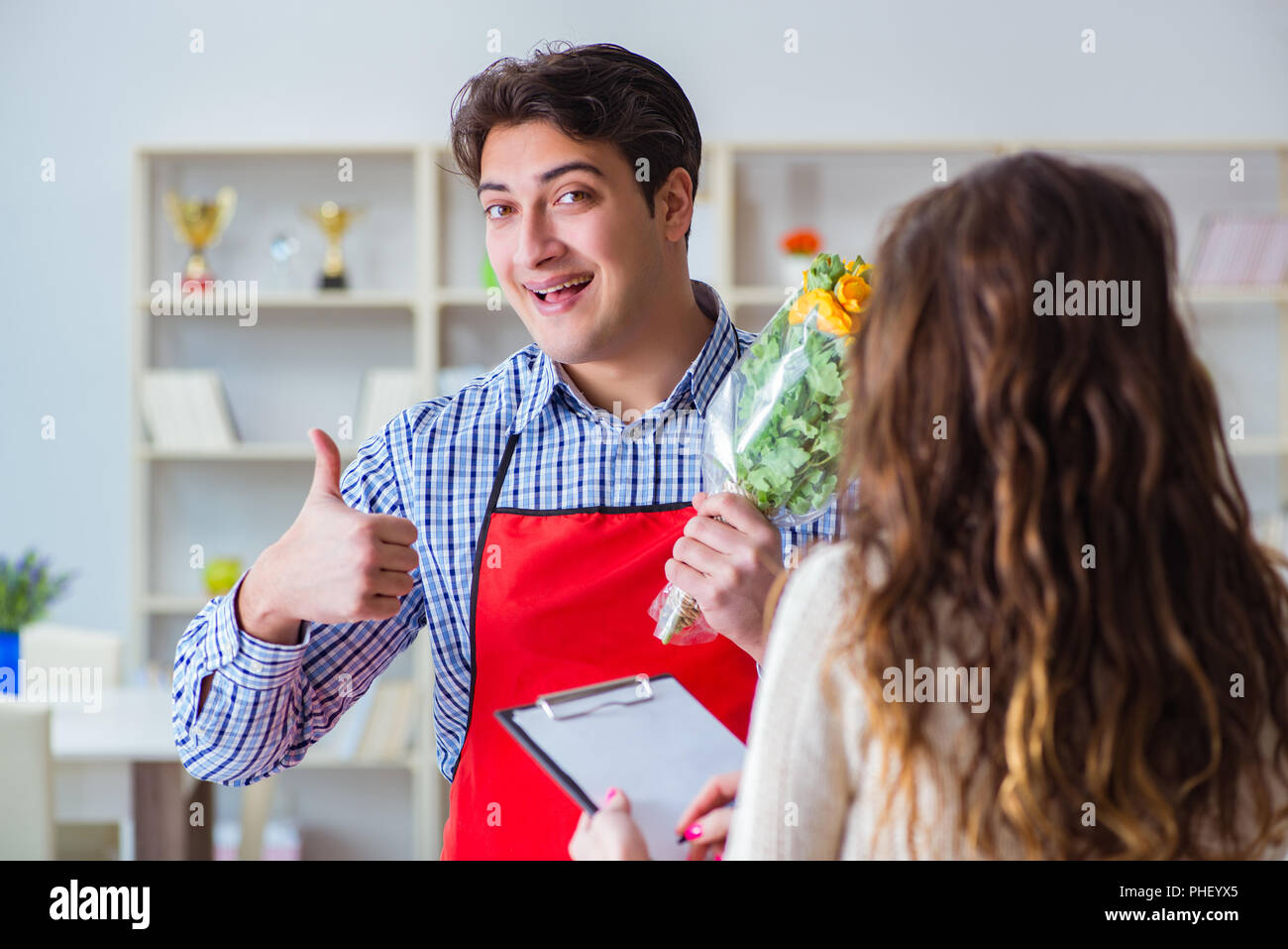 Flower shop assistant selling flowers to female customer Stock Photo ...