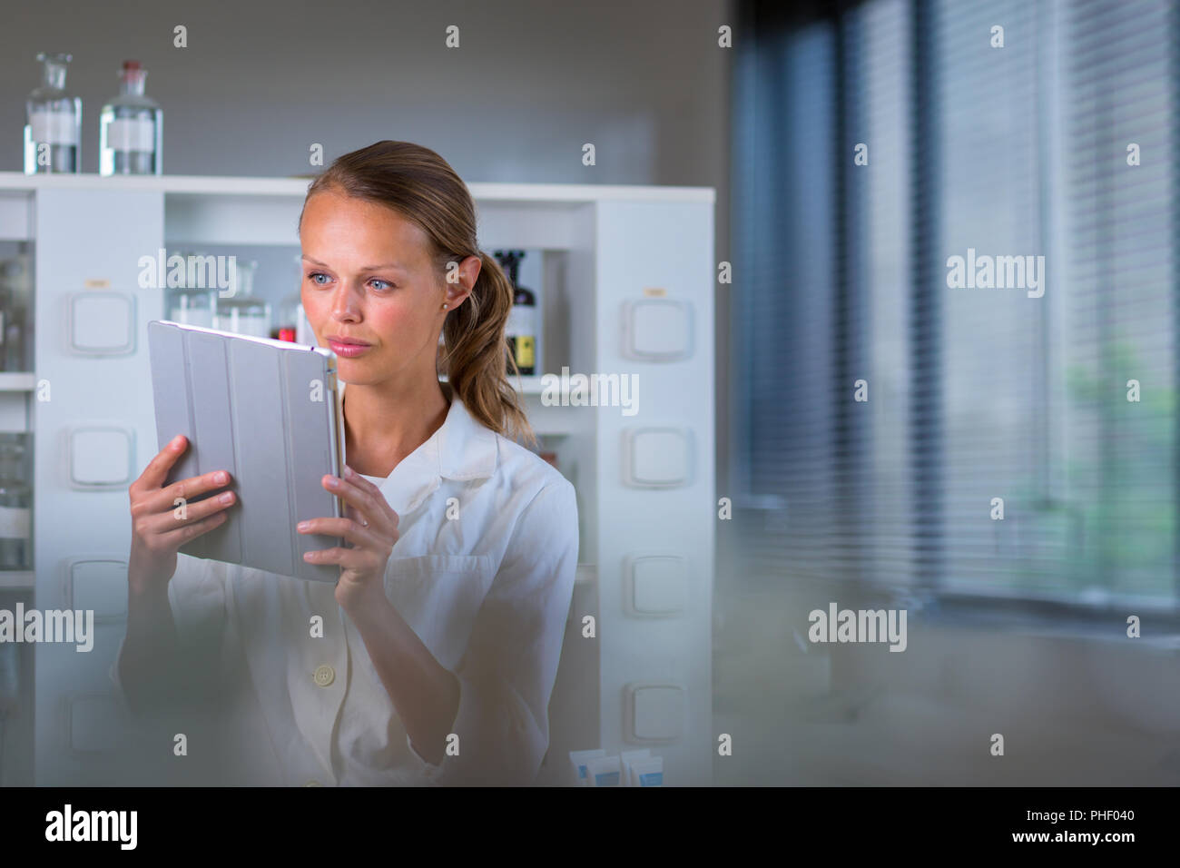 Portrait of a female researcher doing research in a lab, using a tablet ...