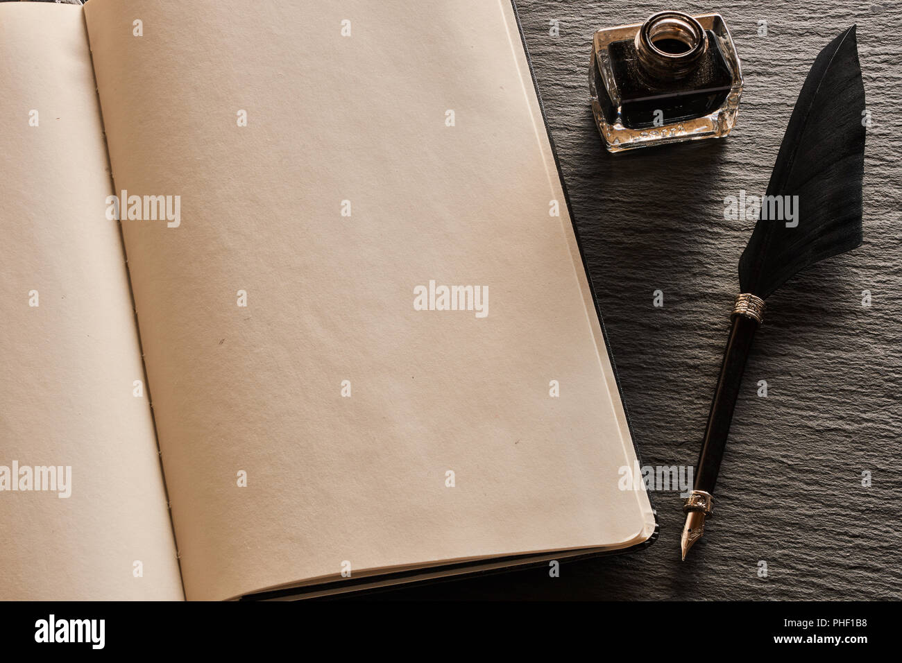 Feather pen and blank notebook page Stock Photo - Alamy